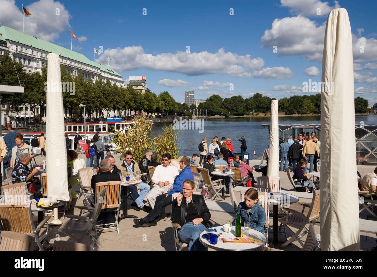 People sitting in the open-air area of the restaurant Alsterpavillon ...