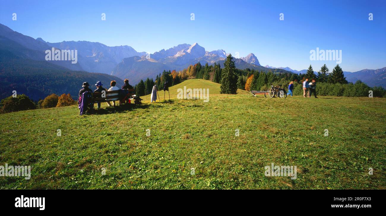 Hiker sitting on bench, Graseck, View to Wetterstein and Zugspitze ...