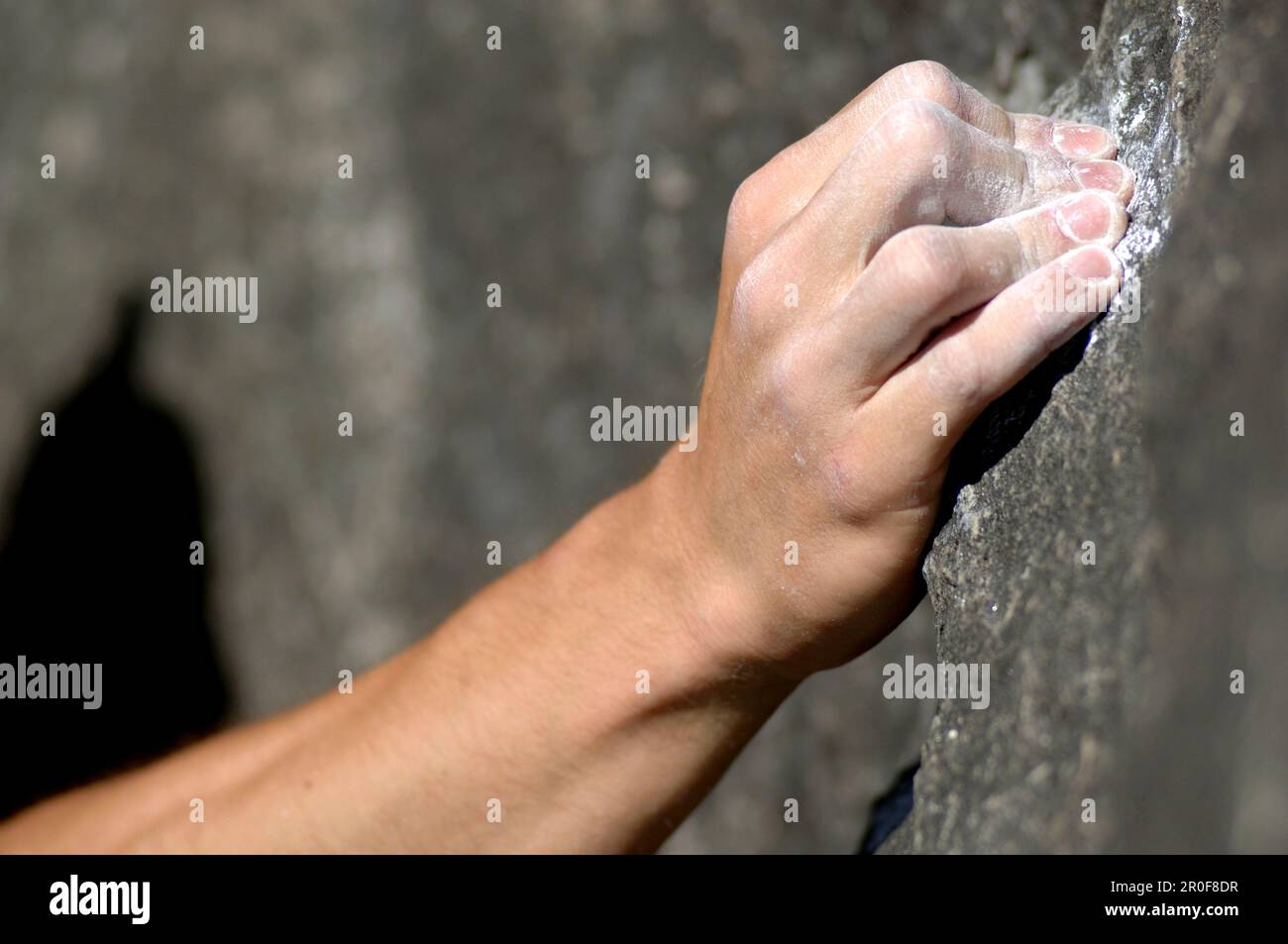 Climber's hand holding on rock face Stock Photo - Alamy