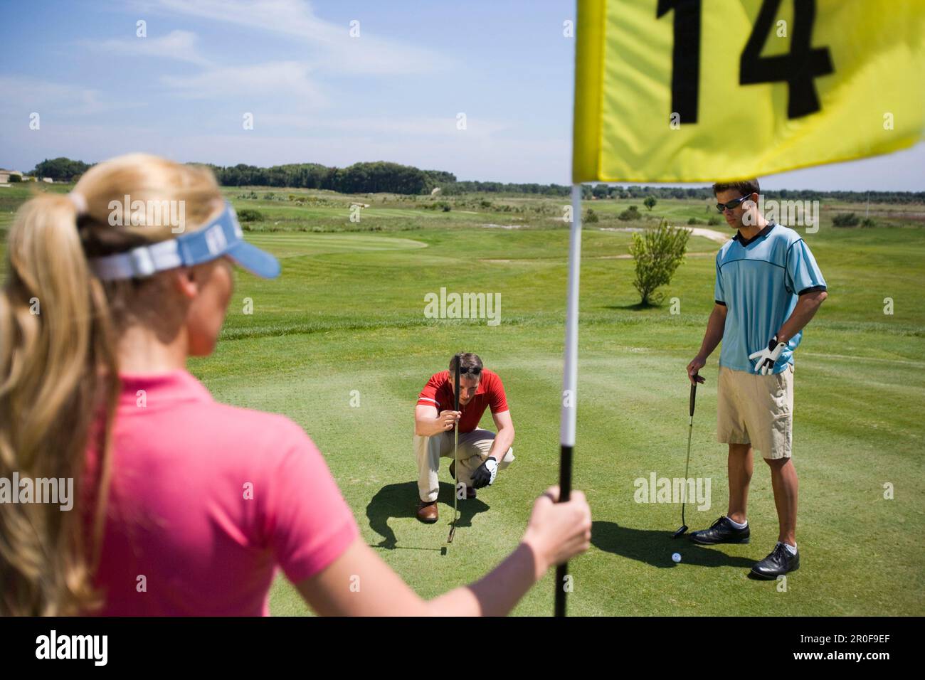 Male golfer preparing to hit ball, young woman giving pointers, Apulia, Italy Stock Photo - Alamy