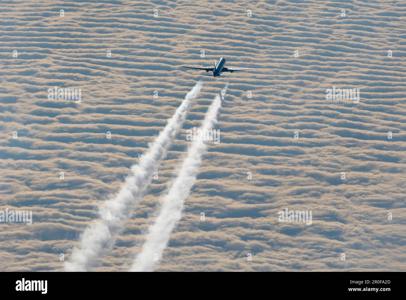 Aircraft with contrails overhead cloud layer Stock Photo - Alamy