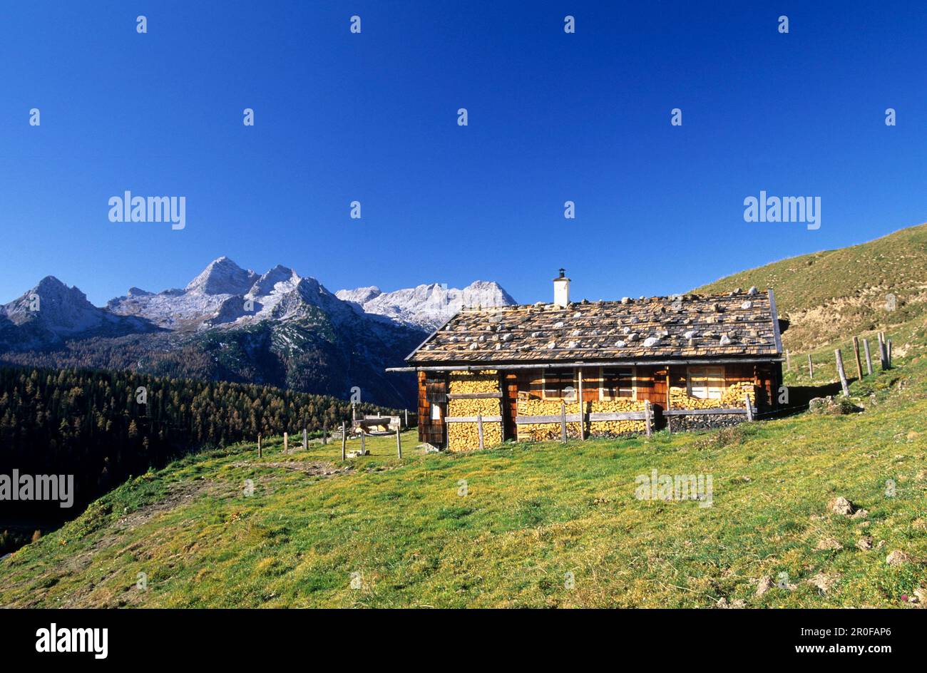 Traditional alpine hut with shingle roof in front of Leoganger ...