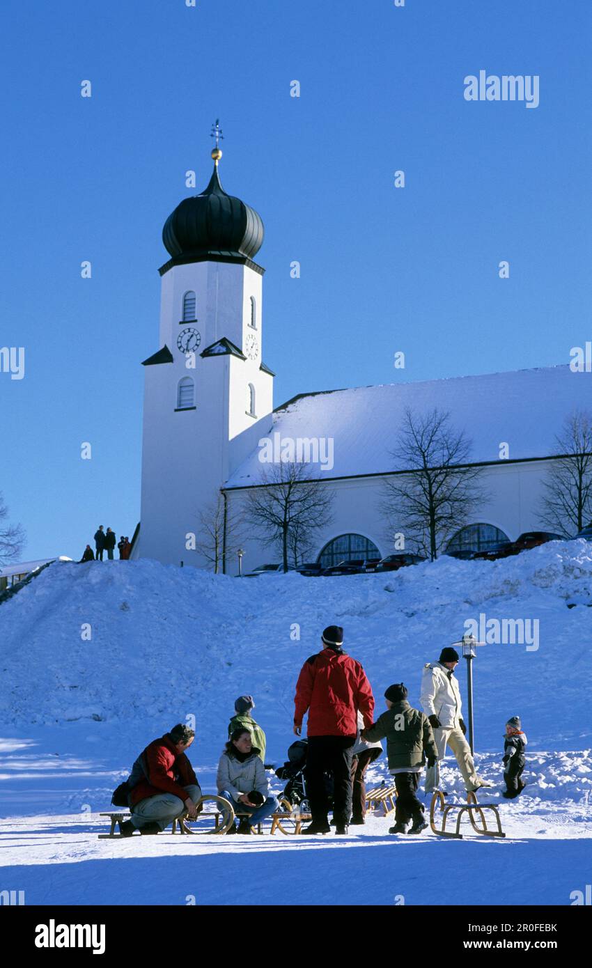 People with sleds, church in background, Sulzberg, Vorarlberg, Austria ...