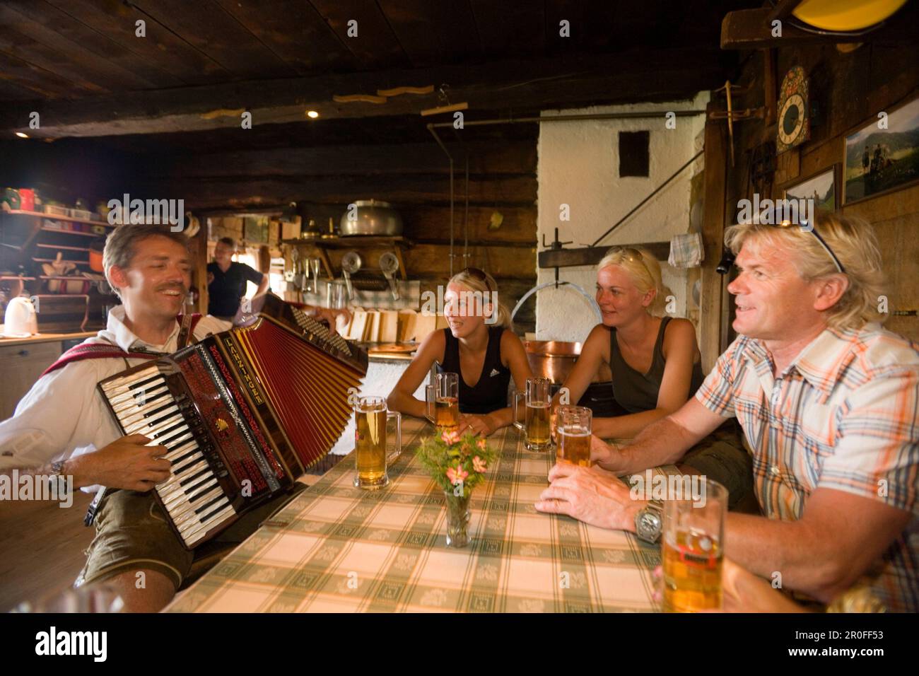 Group of tourists sitting inside a mountain hut and drinking beer while ...