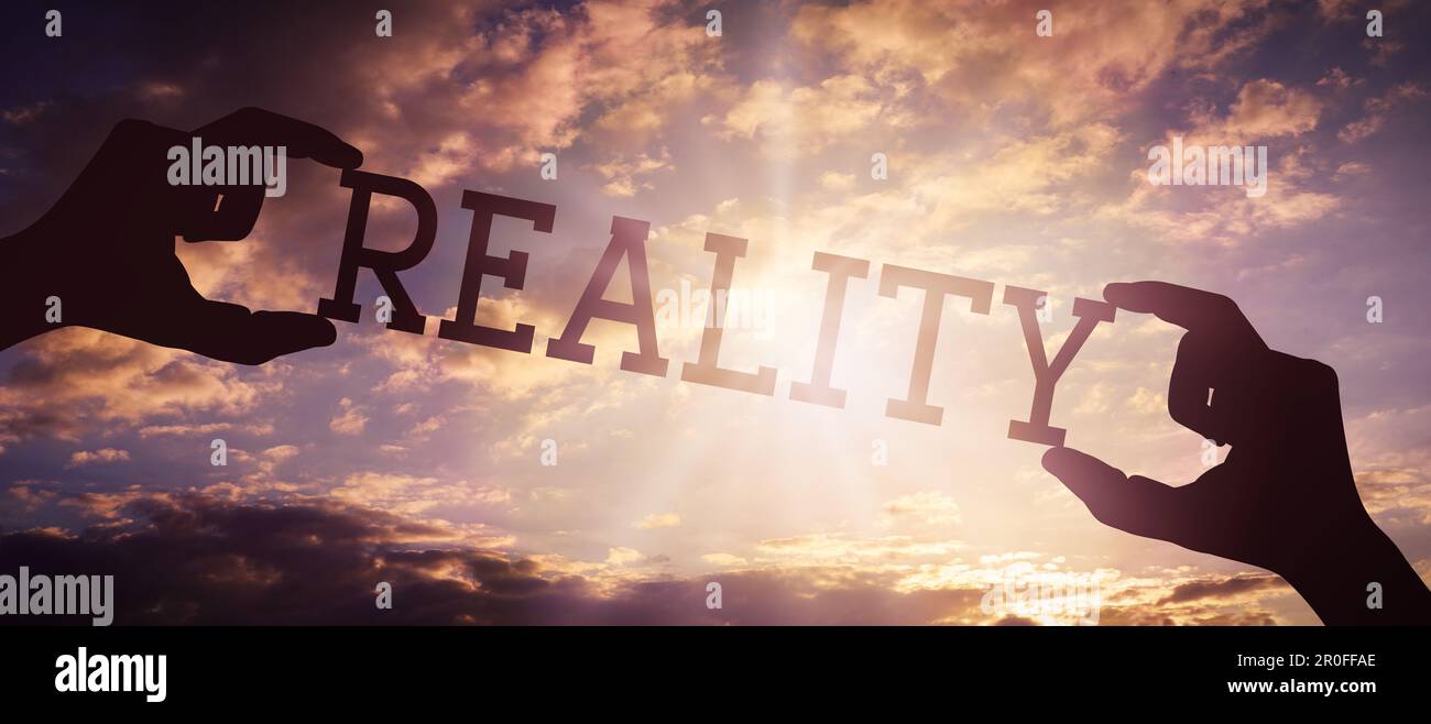 Reality - human hands holding black silhouette word Stock Photo - Alamy