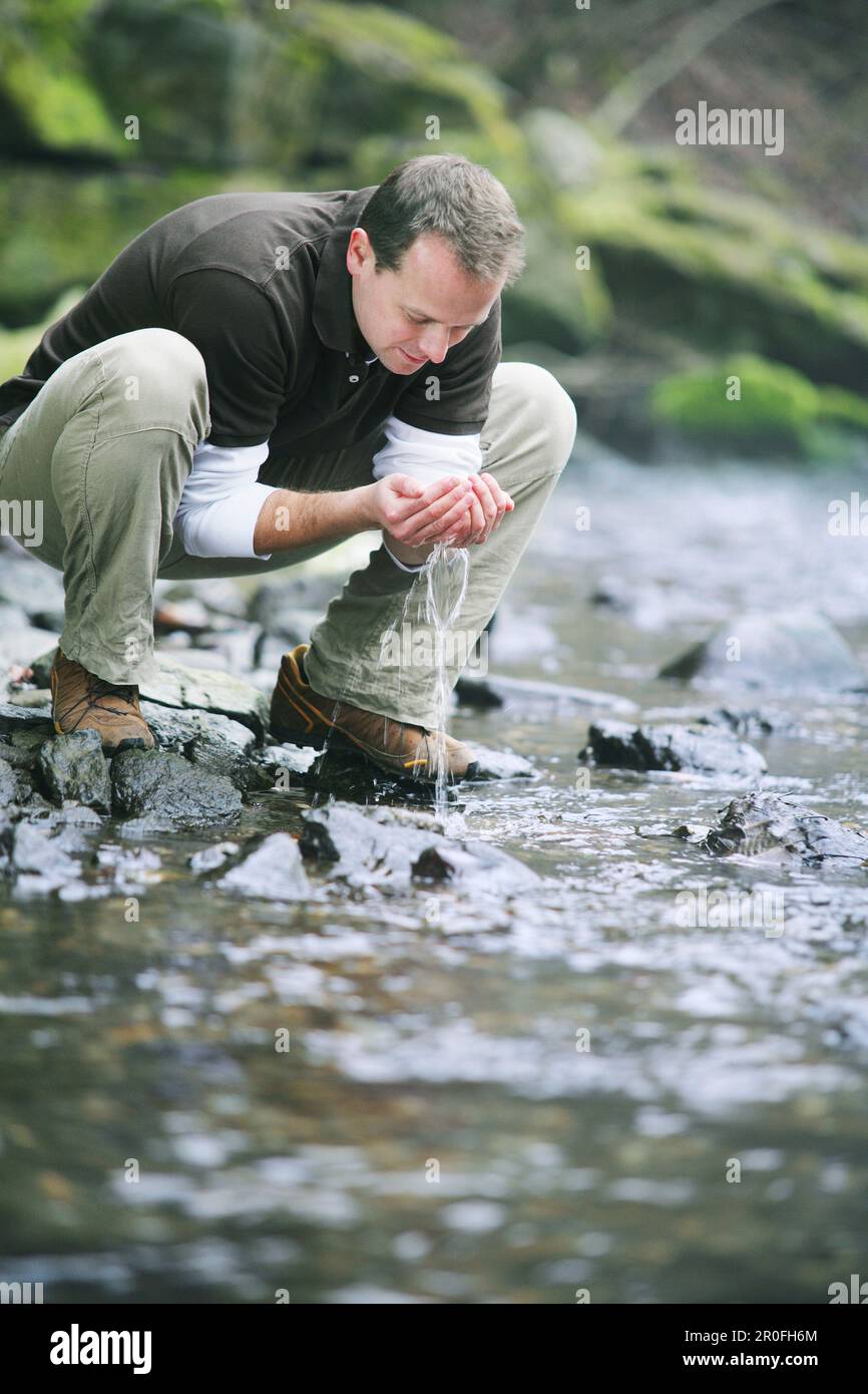 Man drinking water from a stream Stock Photo - Alamy