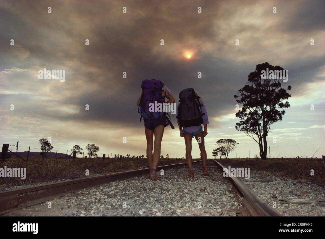 Two hikers walking along train tracks in the early morning Stock Photo ...