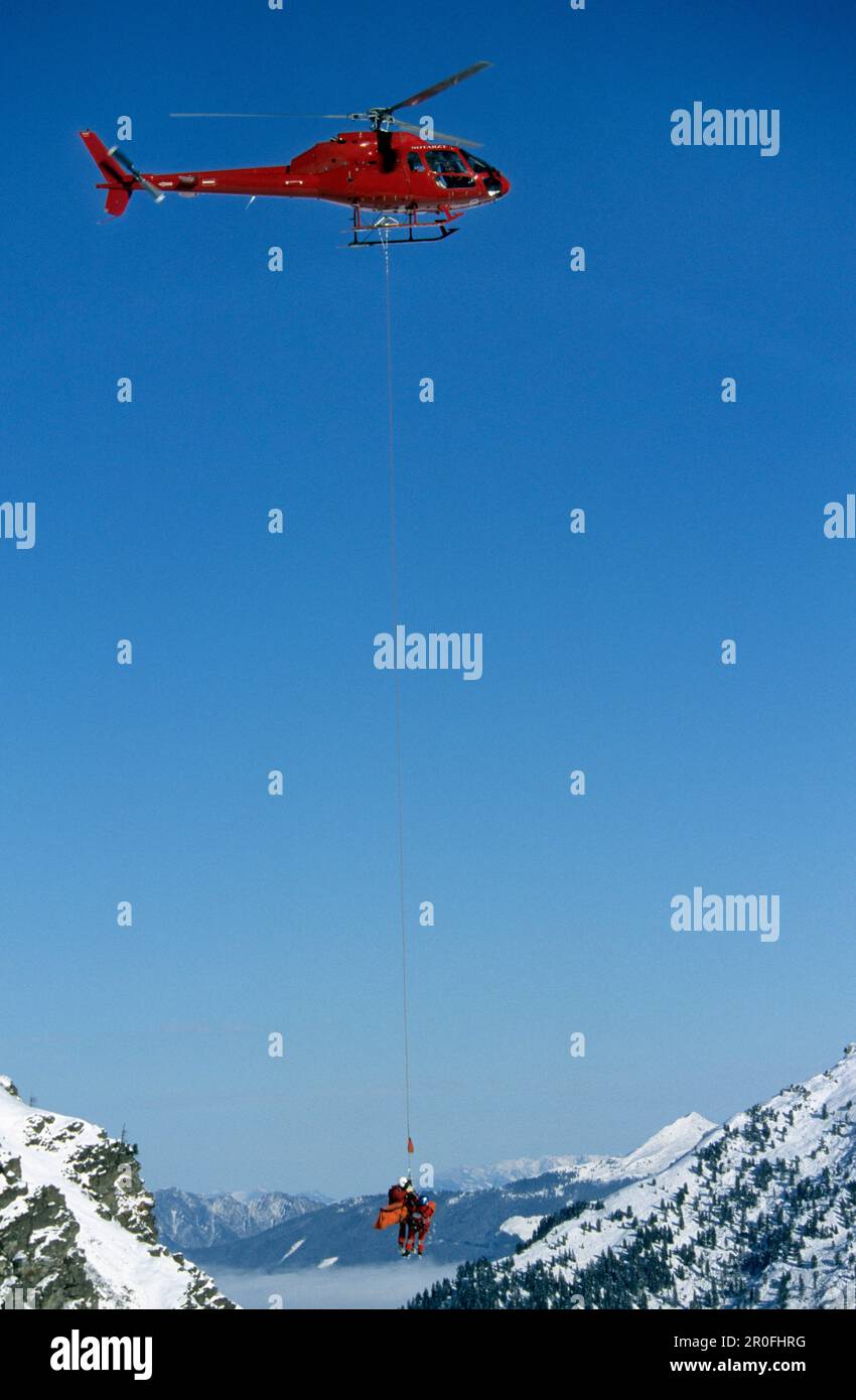 Helicopter rescueing an injured person in the mountains, rescue team ...