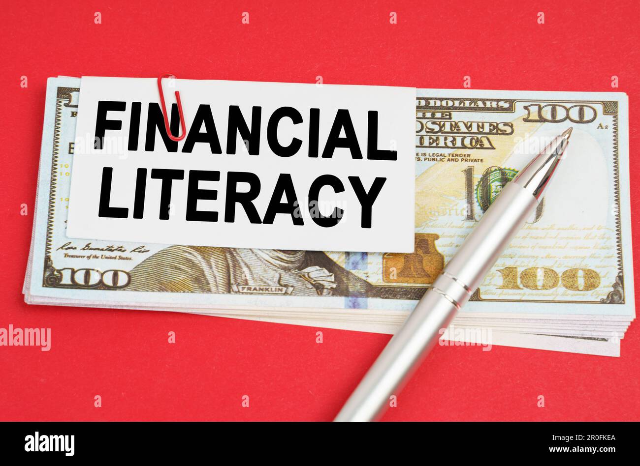 Business concept. On a red surface are dollars on which a pen and paper ...