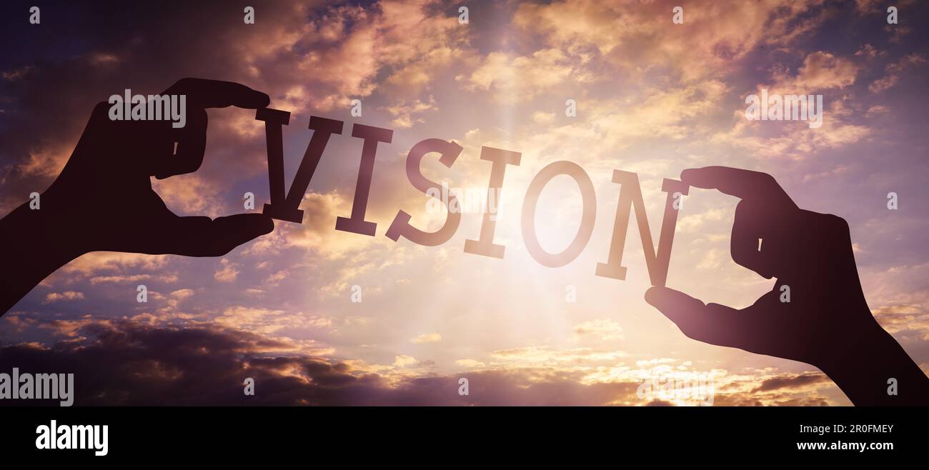 Vision - human hands holding black silhouette word Stock Photo - Alamy