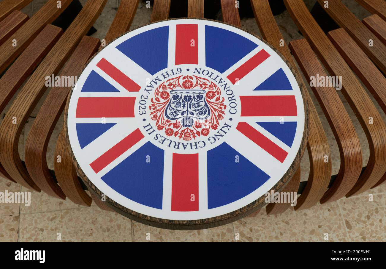 Union flag and coronation emblem forming table top for wooden seating ...
