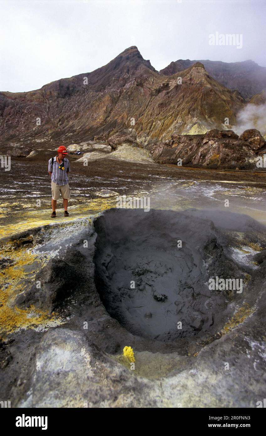 Tourist looking at boiling hot mud on White Island, North Island, New ...