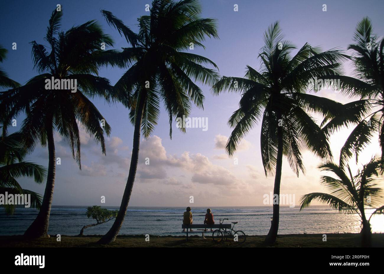 Two cyclists having a rest on a park bench on West Island, Australian ...