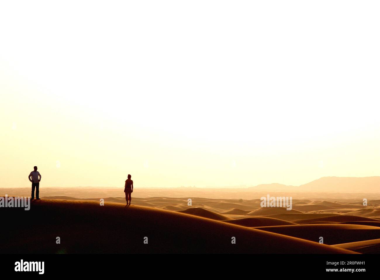 Silhouette of Couple in the Desert watching sun set, Dubai, United Arab ...