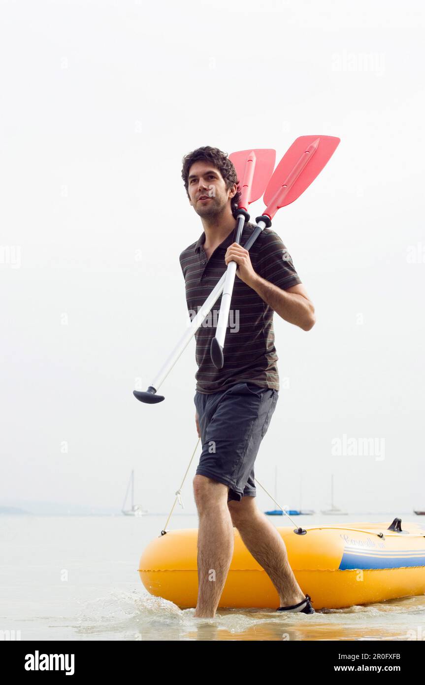 Young man pulling dinghy, lake Ammersee, Bavaria, Germany Stock Photo ...