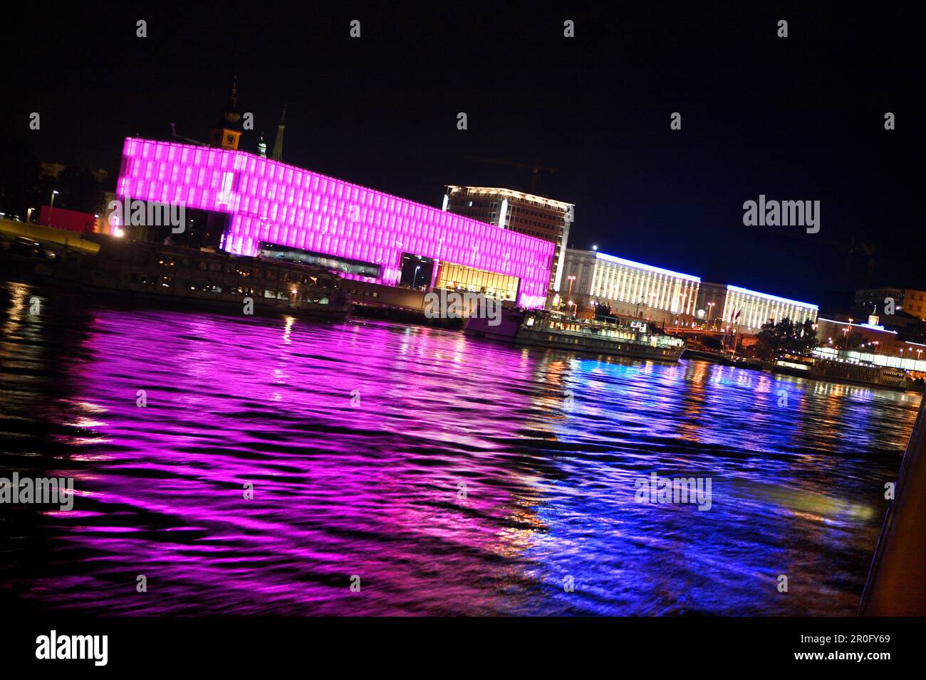 View over river Danube to illuminated Lentos Art Museum at night, Linz ...