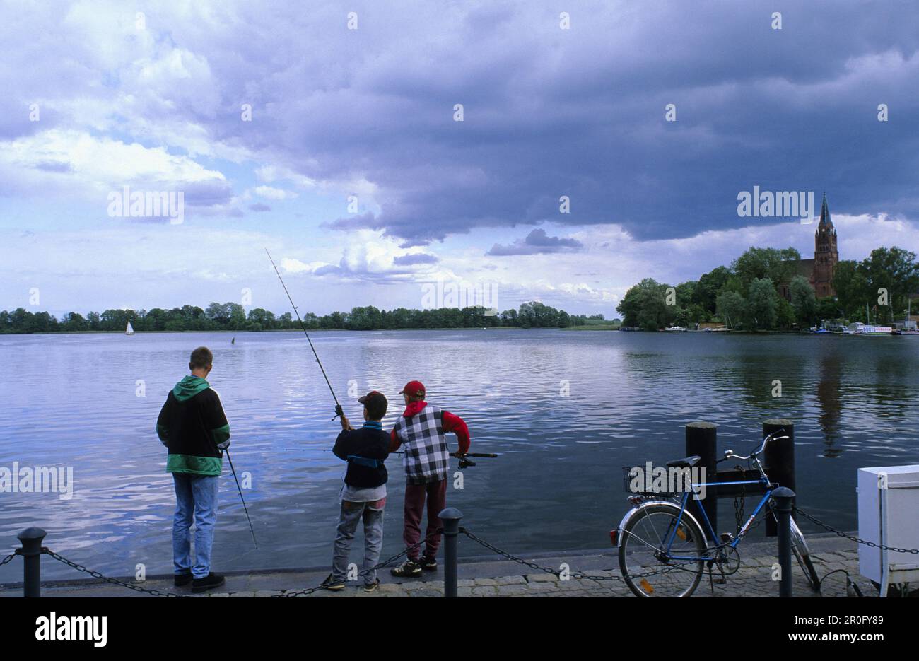 Children fishing at lake Muritz, Robel, Mecklenburg Western-Pomerania ...