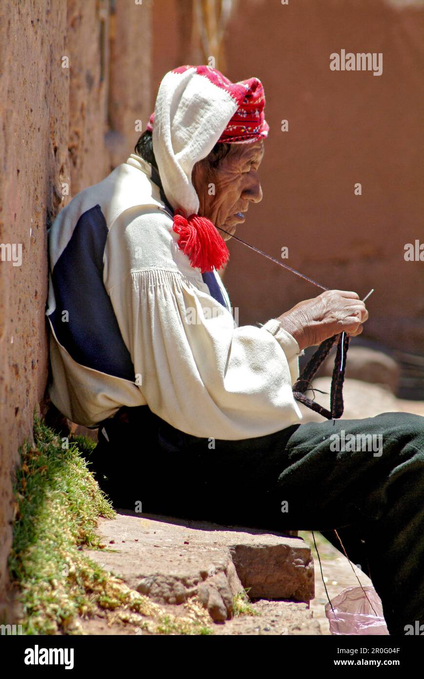 Indigenous man knitting on the island of Taquille, Lake Titicaca, Peru ...