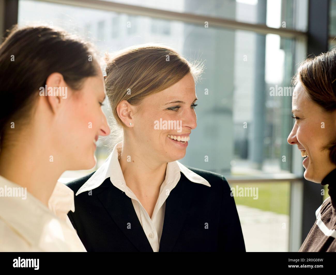 Three businesswomen talking and laughing, Munich, Bavaria, Germany ...
