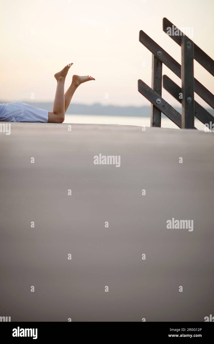 Woman lying on jetty at lake starnberg hi-res stock photography and images - Alamy