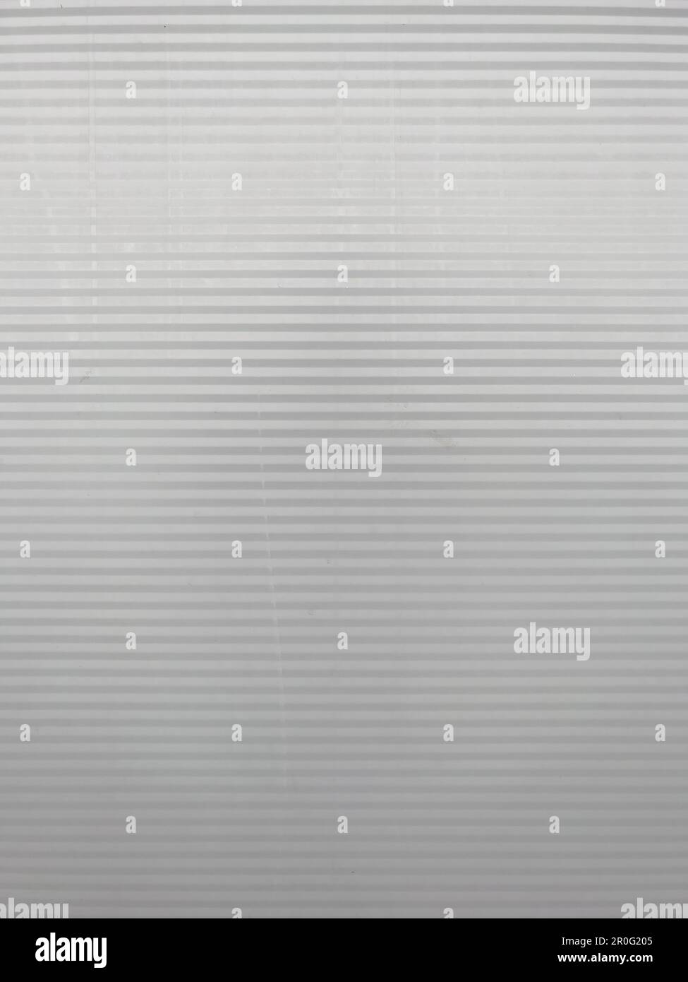 An interior window with white shutters closed, allowing light to filter ...