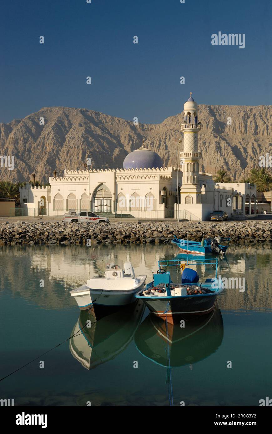 View at fishing boats at harbour and a mosque in the sunlight, Khasab ...