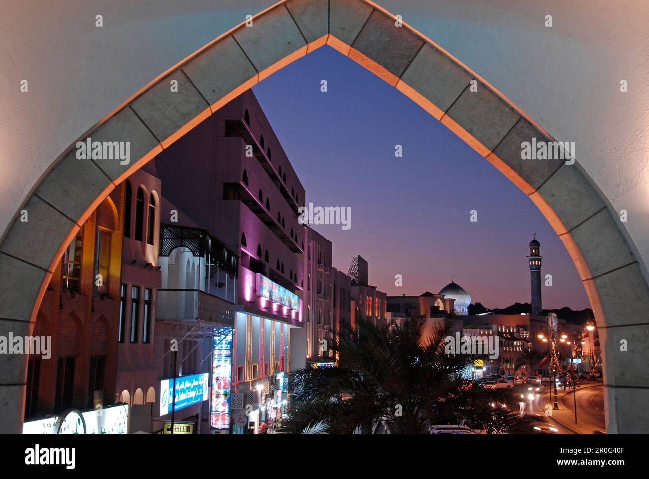 View through a gate at hte illuminated houses of the Matrah district ...