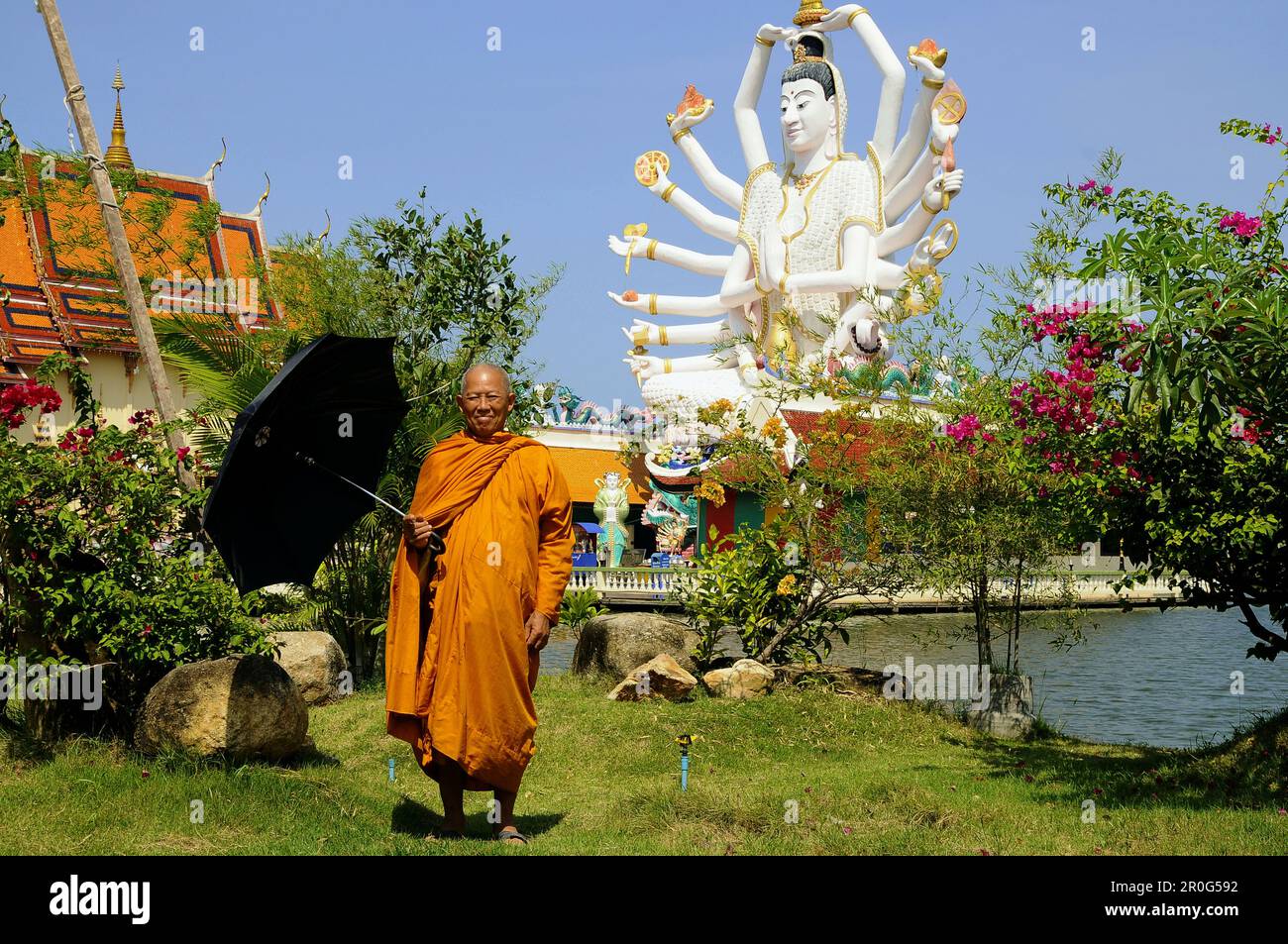 Monk holding umbrella at Nuam Na Ram Temple, North coast, Ko Samui ...
