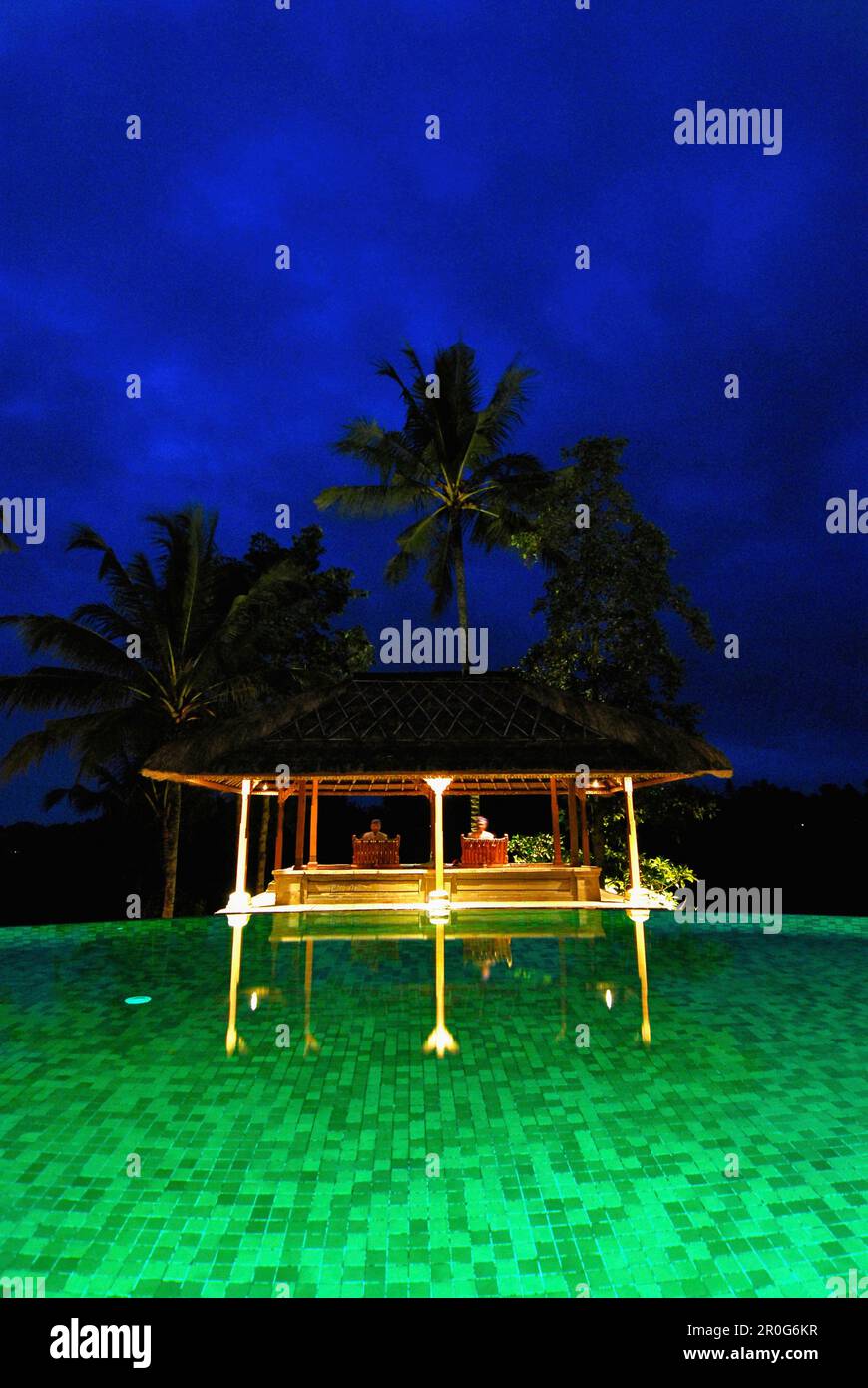 Illuminated pavilion at the pool of Amandari Resort in the evening, Yeh ...