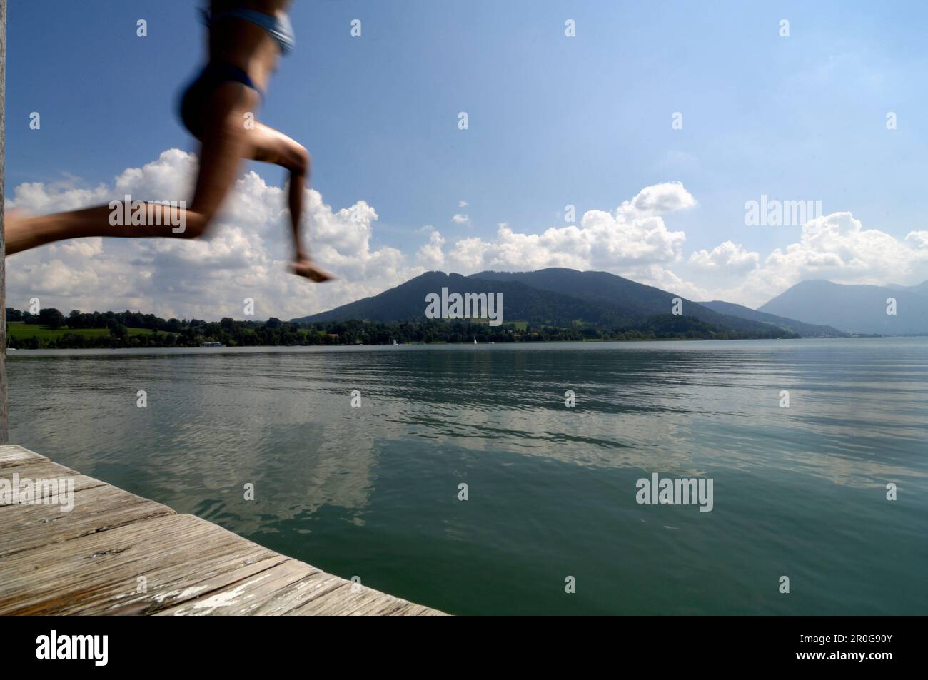Young woman jumping into a lake, near Gmund, Lake Tegernsee, Upper ...
