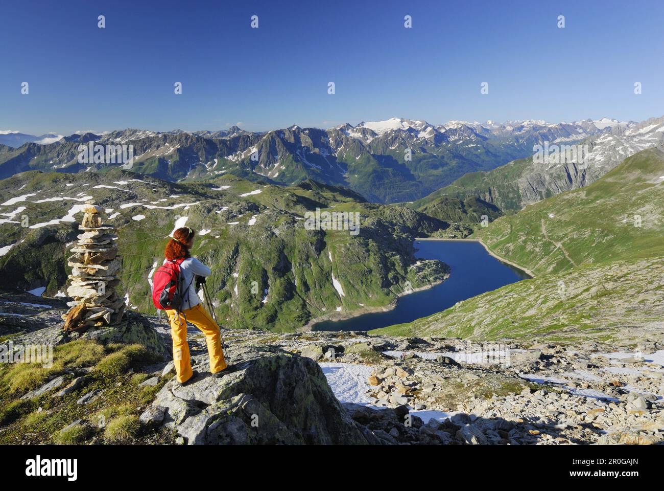 Woman looking over reservoir Lago della Sella to Ticino Alps, Gotthard ...