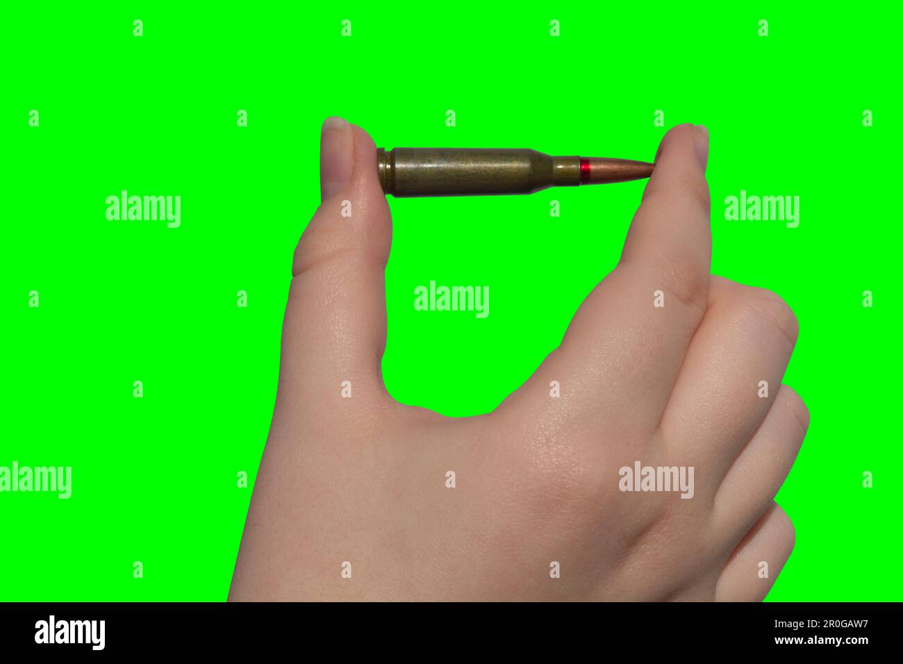 Rifle cartridge in hand on a green background (chroma key). Close-up ...