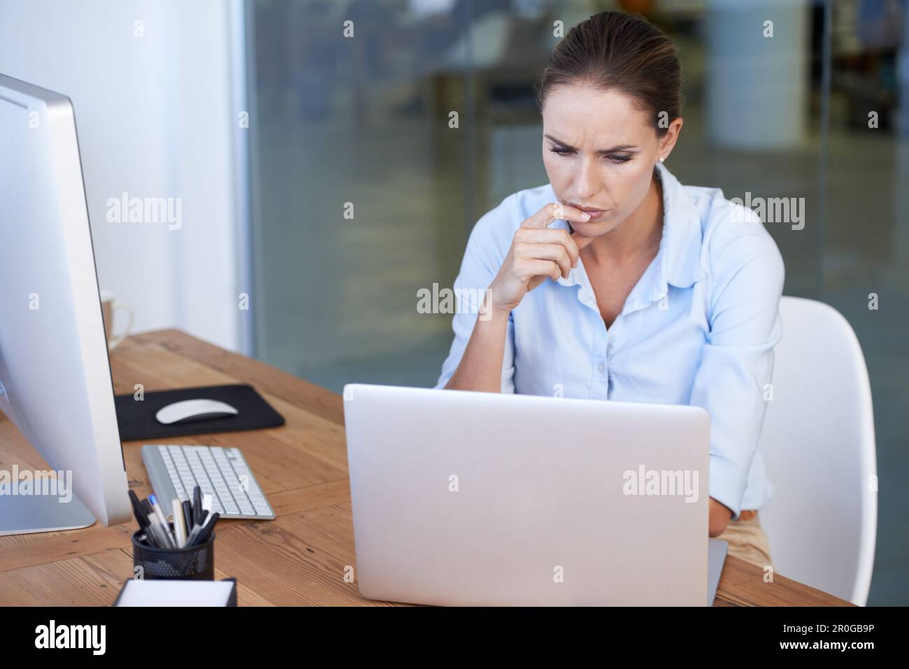 Confused, business woman and thinking at laptop for decision, choice of ...