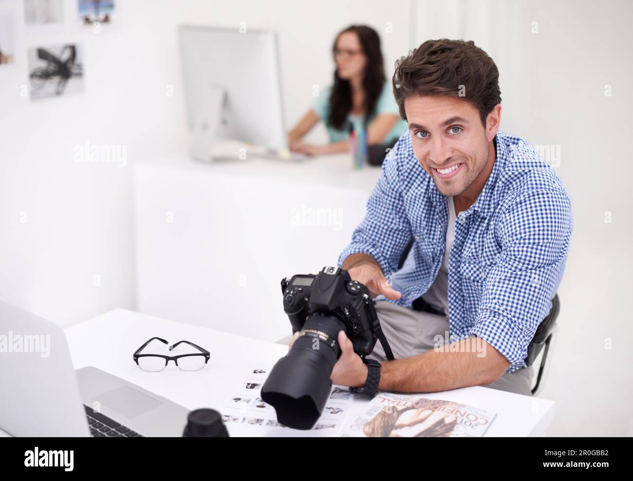 Using the tools of the trade. Two photographers sitting in their office ...