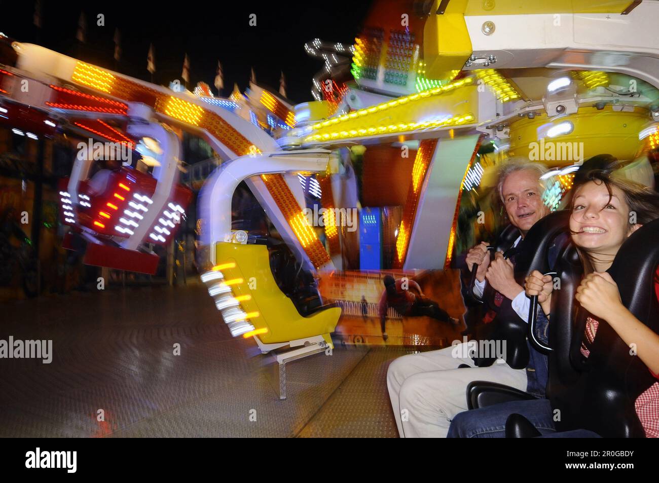 A man and a girl on a fun ride on the Oktoberfest, Munich, Bavaria ...