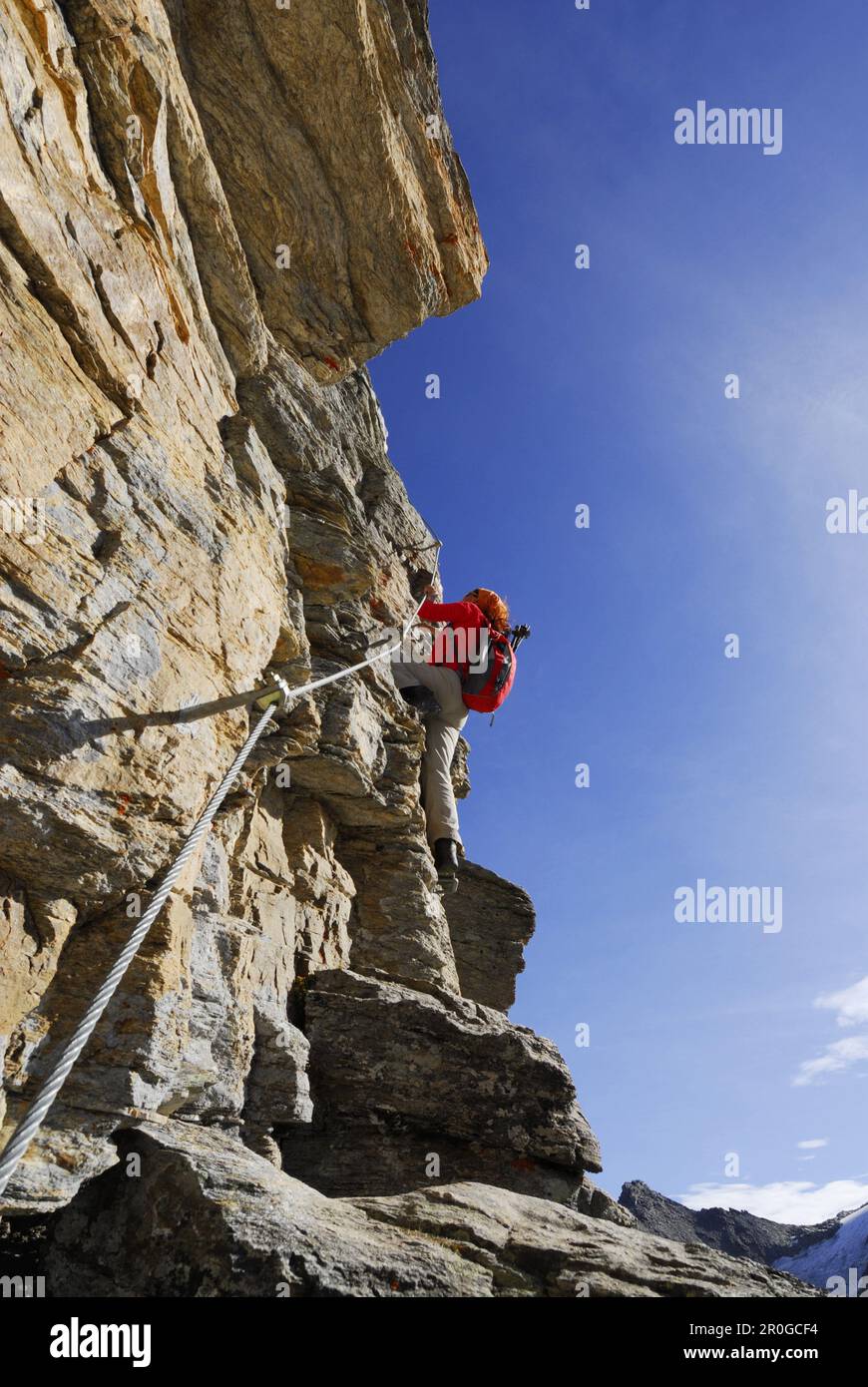 Woman climbing fixed rope route through Tschenglser Hochwand, Ortler ...