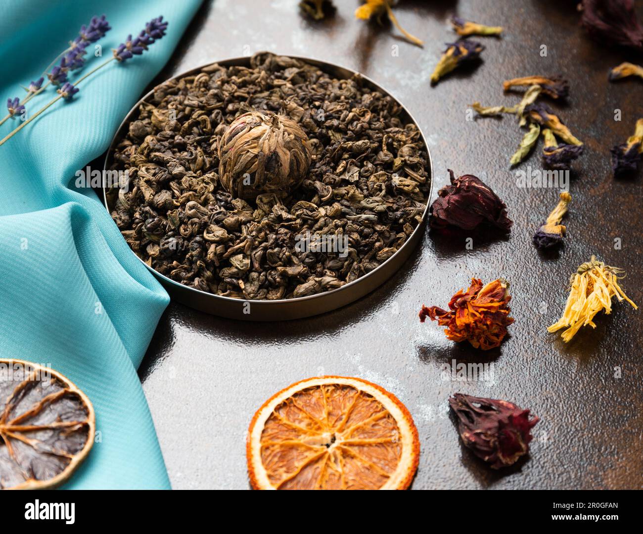 Composition of green, flower tea and dried orange slices on blue and ...