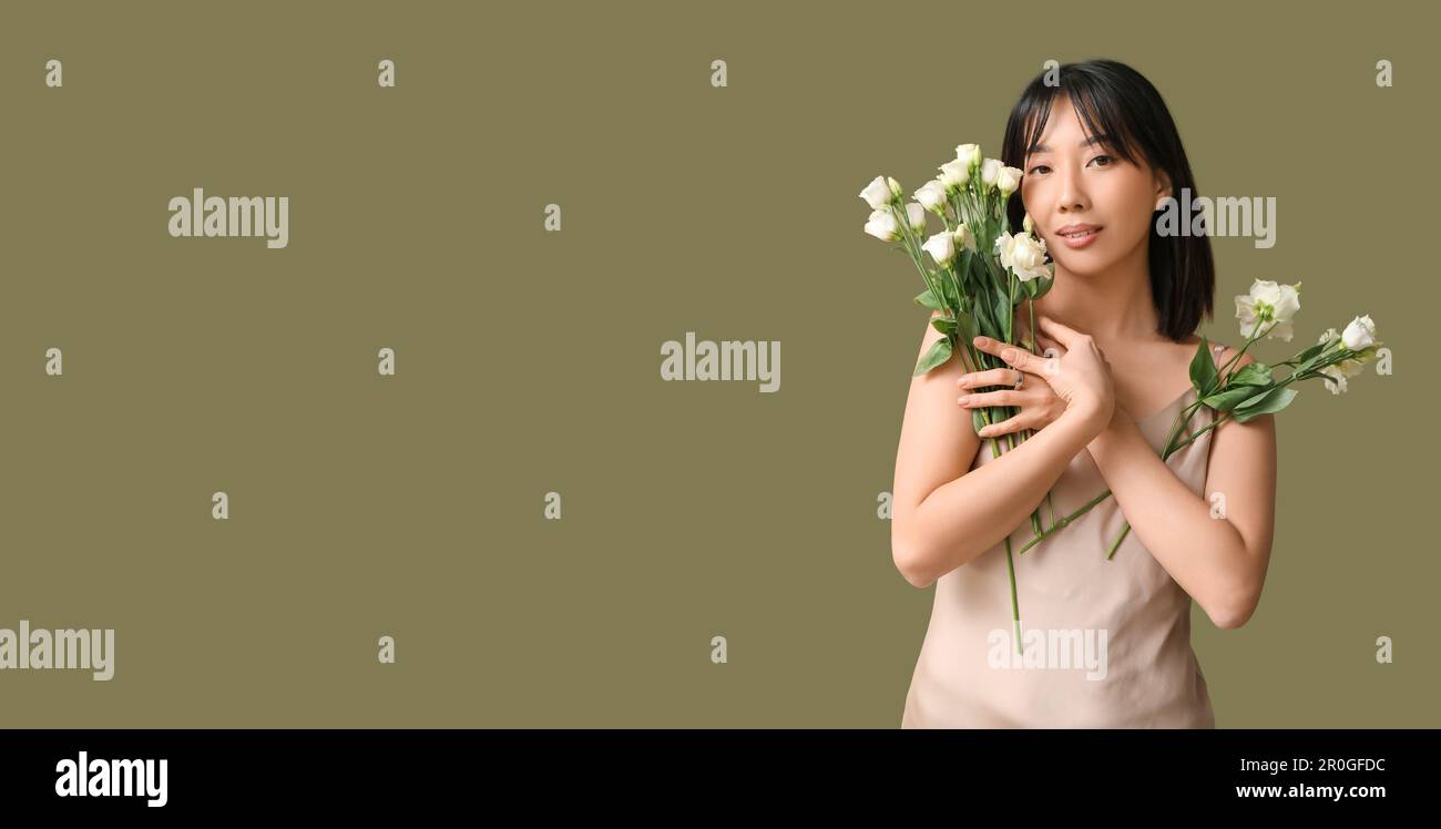 Pretty Asian woman holding bouquet of eustoma flowers on color ...