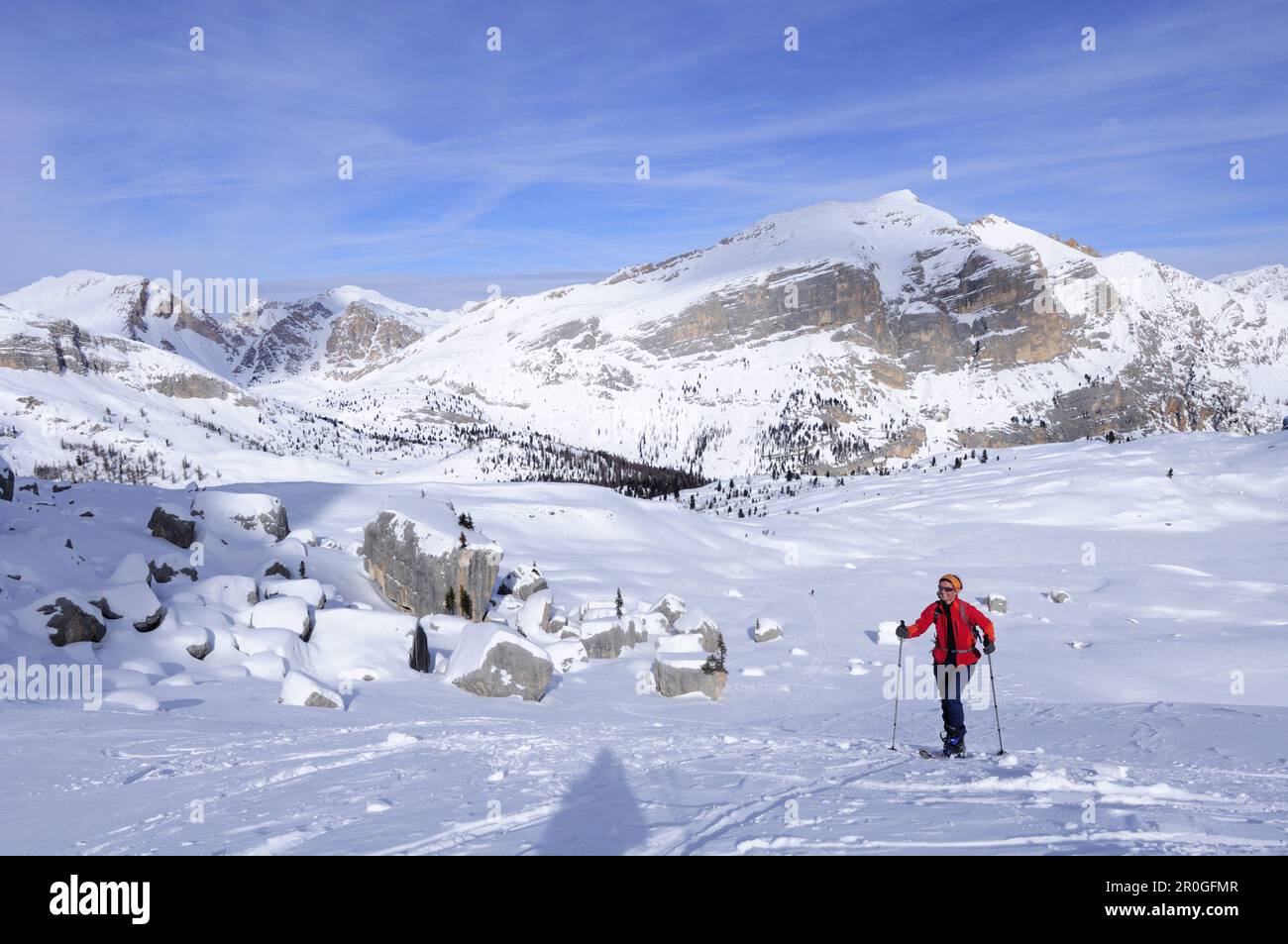 Woman backcountry skiing, ascending, Dolomite summits in the background ...