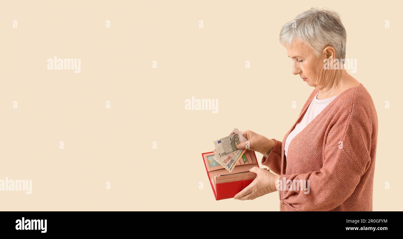 Elderly woman with dollars and wallet on light background with space ...