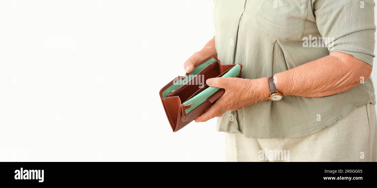 Elderly woman with empty wallet on light background with space for text ...