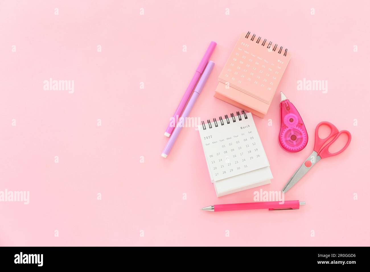 Flip paper calendars and stationery on pink background Stock Photo - Alamy