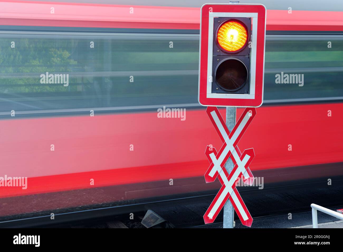 Railroad crossing with St. Andrew´s cross and train passing in the ...