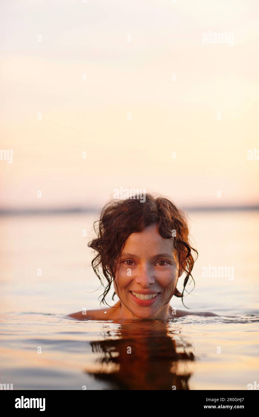 Woman bathing in lake Starnberg, Ambach, Munsing, Bavaria, Germany ...
