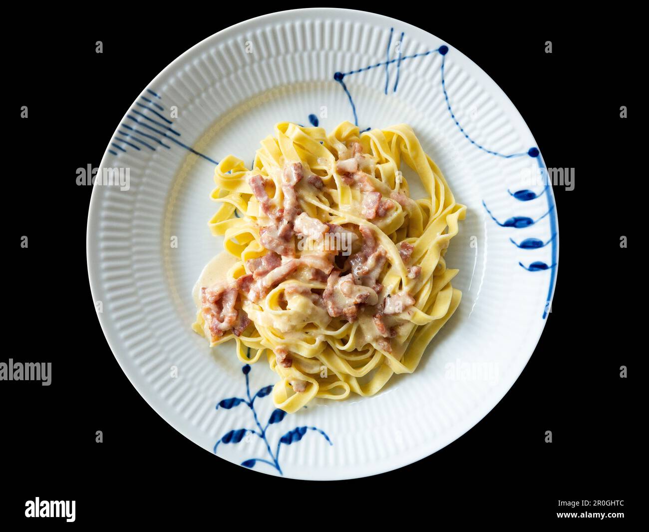 Creamy bacon pasta carbonara. Top view of plate isolated on black ...