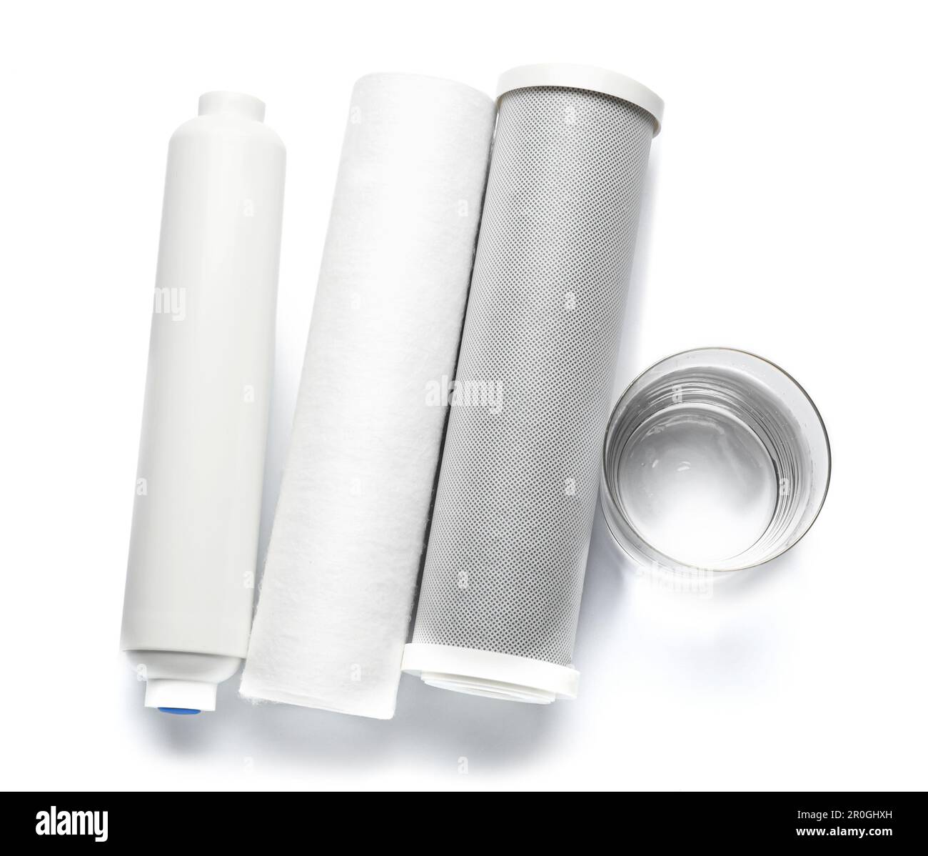 Glass of liquid and water filter cartridges on grey background Stock ...