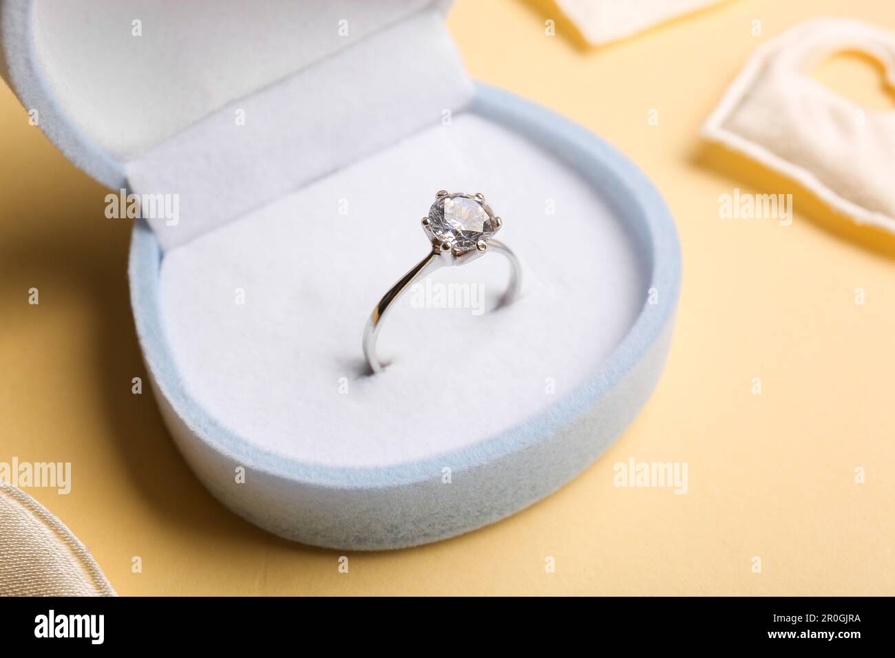 Box with engagement ring and hearts on beige background, closeup Stock ...
