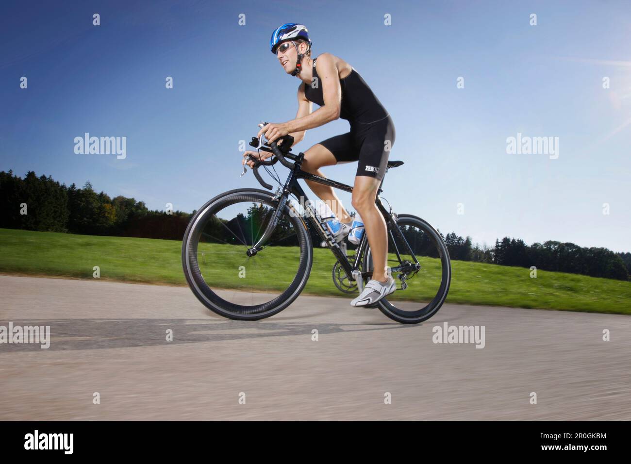 Man cycling with a triathlon bike on road near Munsing, Upper Bavaria ...
