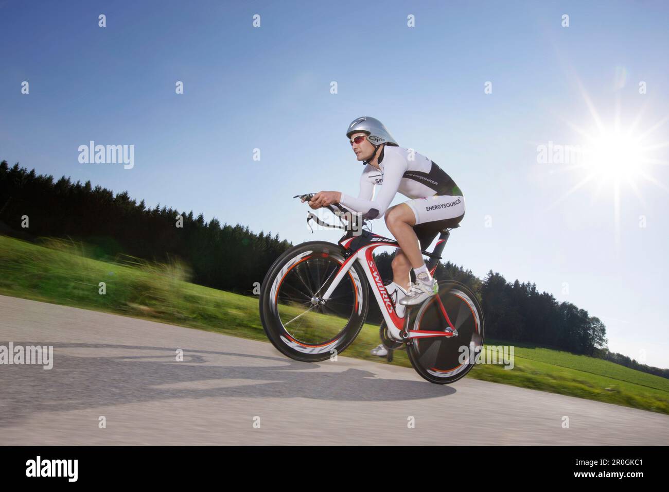 Male racing cyclist with disc wheel on road near Munsing, Upper Bavaria ...