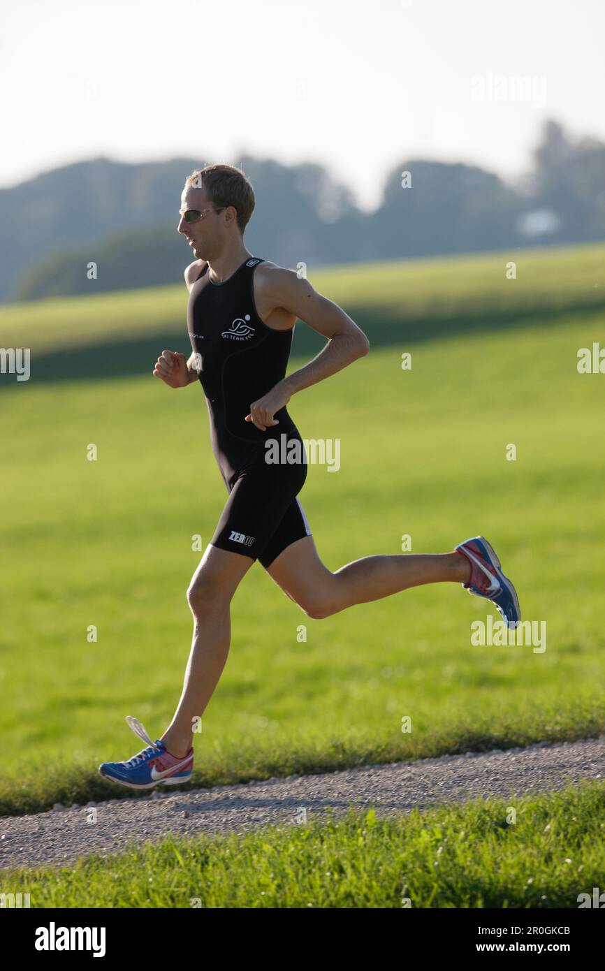 Male runner on path near Munsing, Upper Bavaria, Germany Stock Photo ...